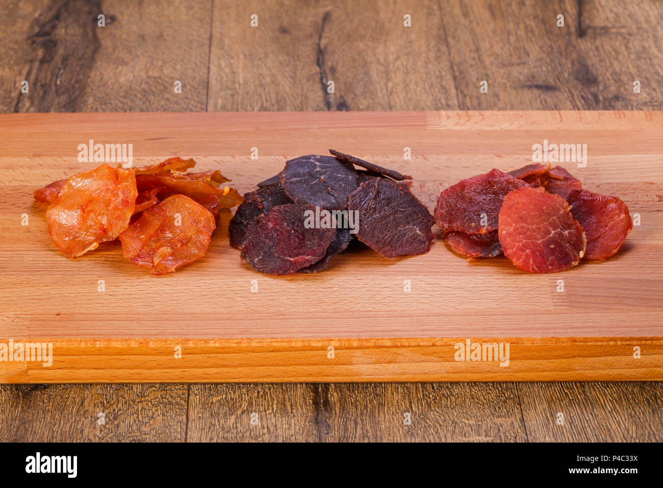 Dry meat snack over the wooden background Stock Photo - Alamy