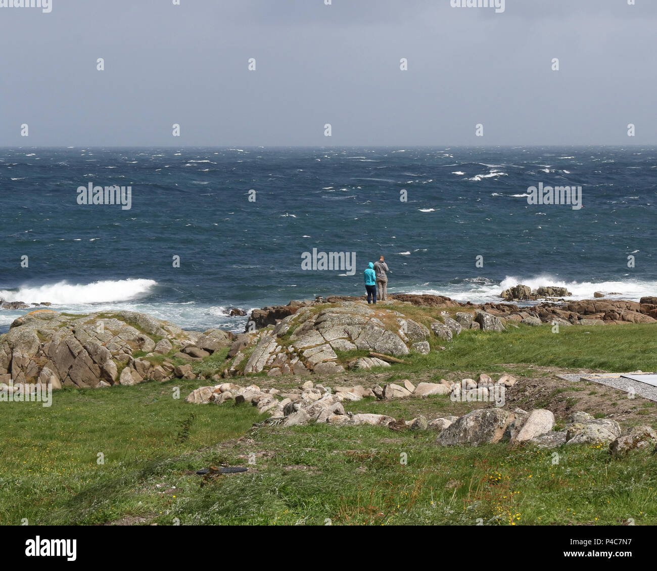 Two people watching waves at Fanad Head Stock Photo - Alamy