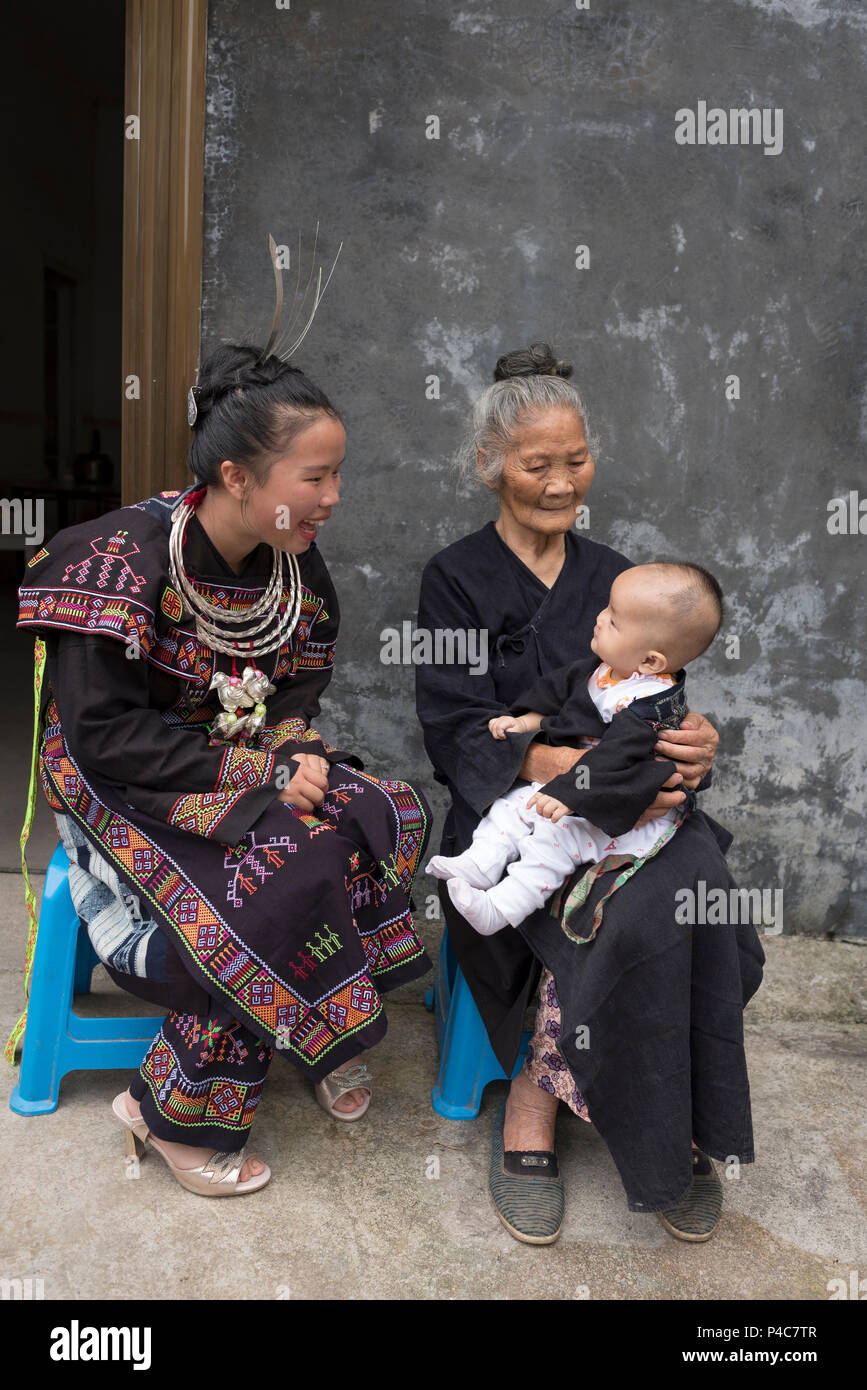 Mother, baby and grandmother dressed in traditional costumes, Yao ...