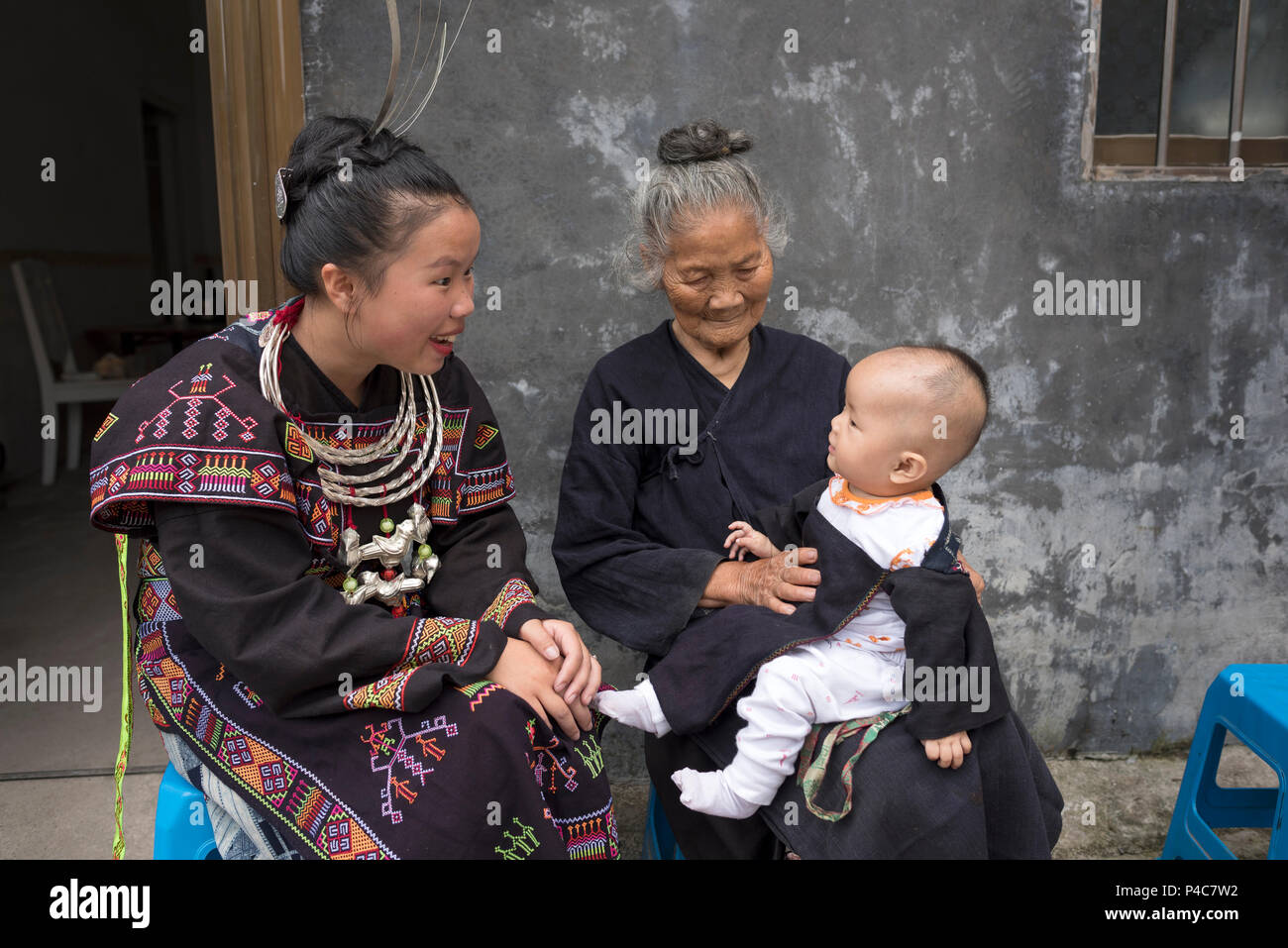 Mother, baby and grandmother dressed in traditional costumes, Yao ...