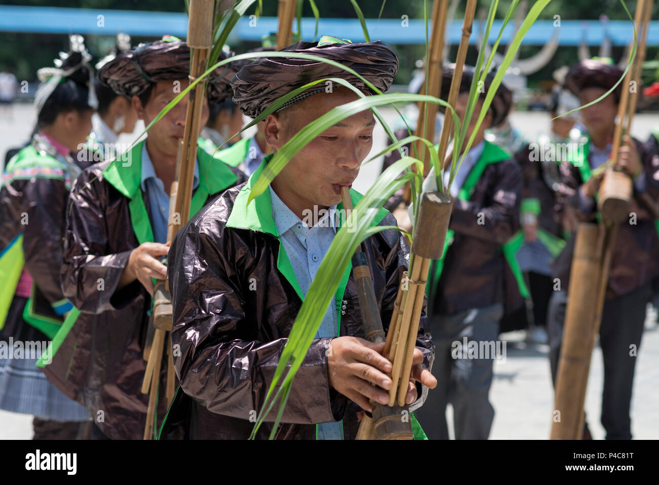 Musicians playing bamboo wind instruments at celebration, Xiaoao Miao ...