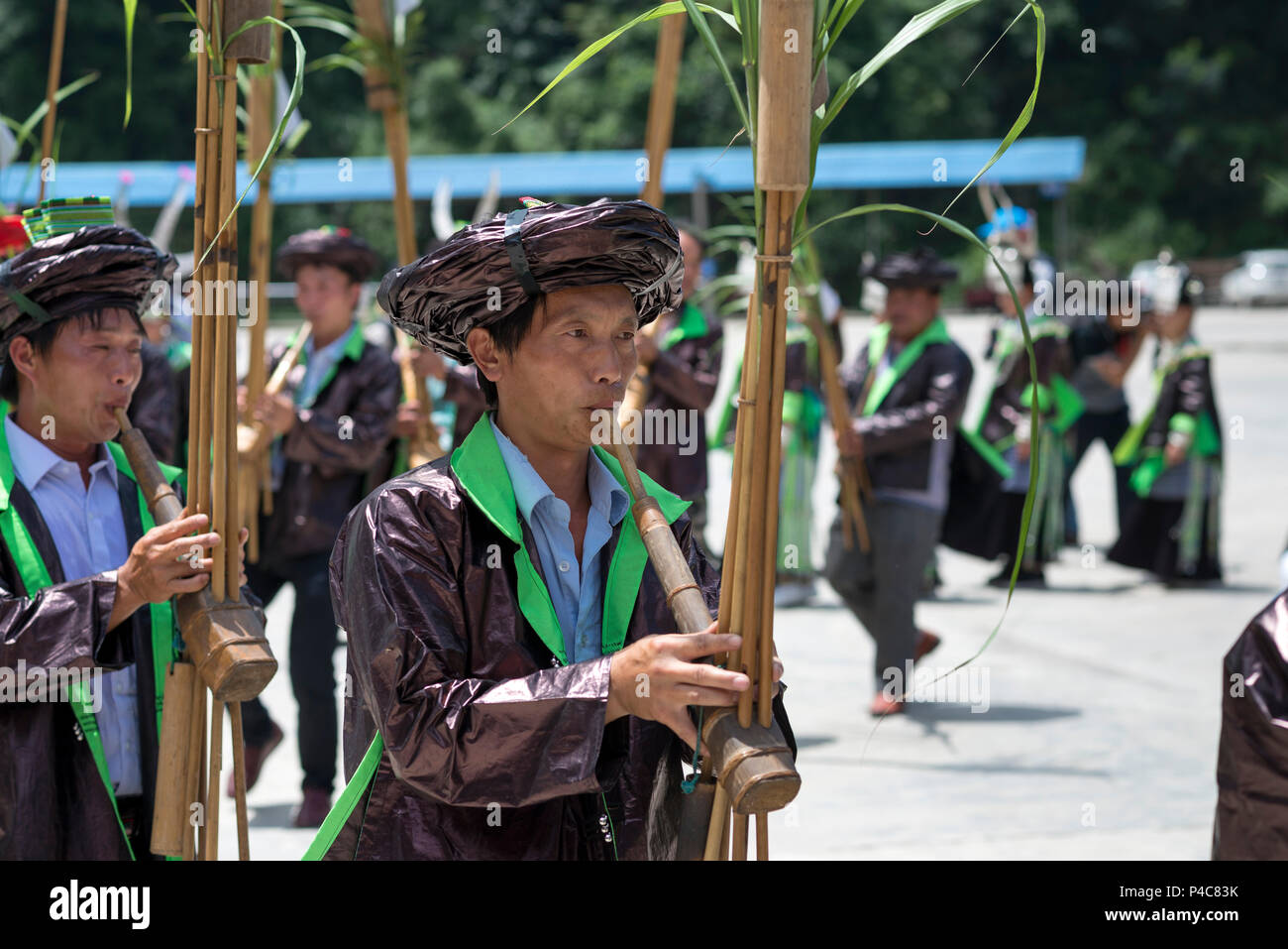 Musicians playing bamboo wind instruments at celebration, Xiaoao Miao ...