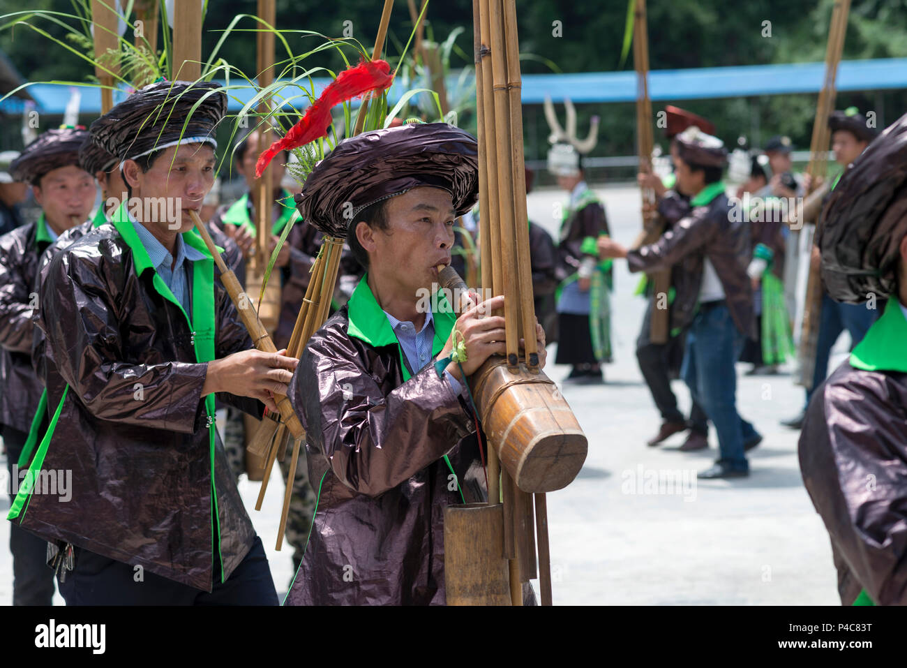 Musicians playing bamboo wind instruments at celebration, Xiaoao Miao ...