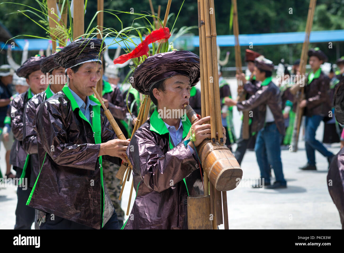 Musicians playing bamboo wind instruments at celebration, Xiaoao Miao ...