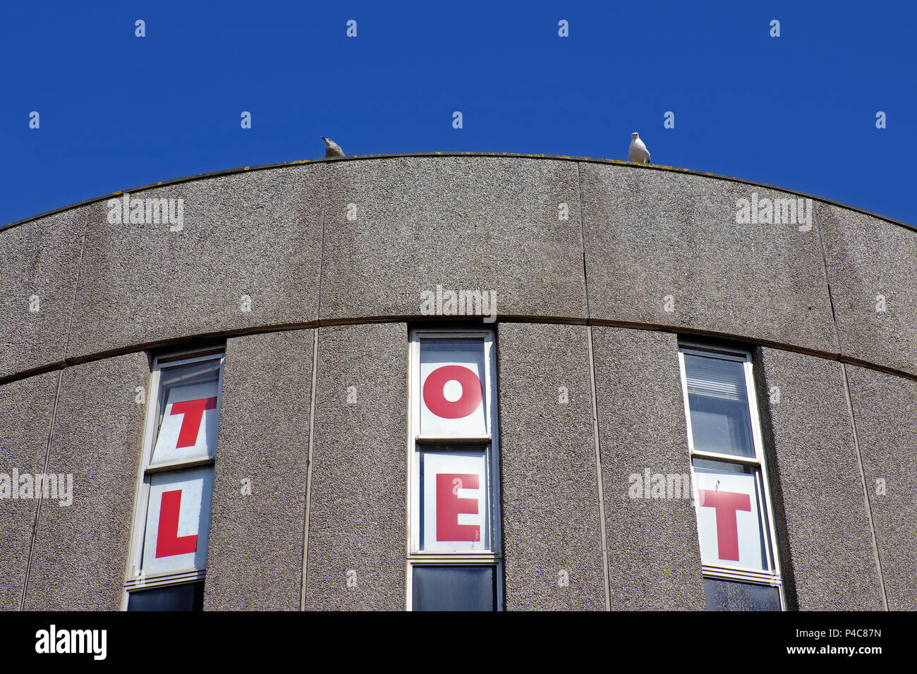 A sign reading “TO LET” in an upper storey window of a building in ...
