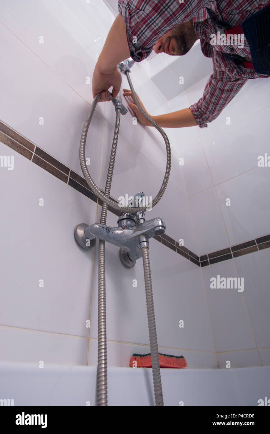 Handyman fixing the shower the bathroom Stock Photo - Alamy