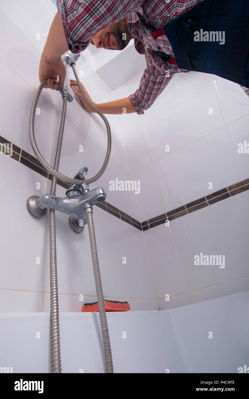 Handyman fixing the shower the bathroom Stock Photo - Alamy