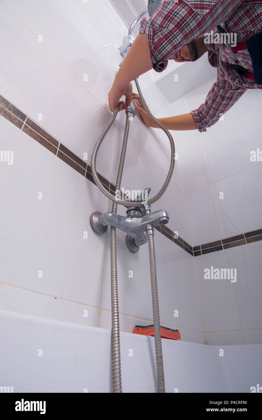Handyman fixing the shower the bathroom Stock Photo - Alamy
