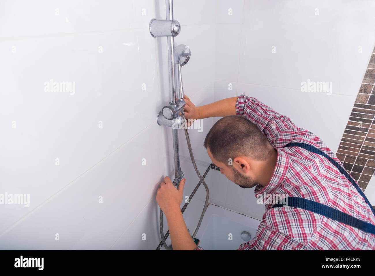 Handyman fixing the shower the bathroom Stock Photo - Alamy