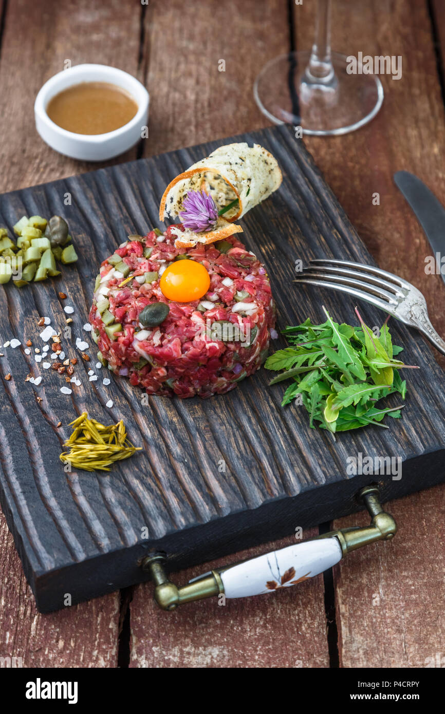 Steak tartare served with capers, pickled cucumbers and chopped onion ...