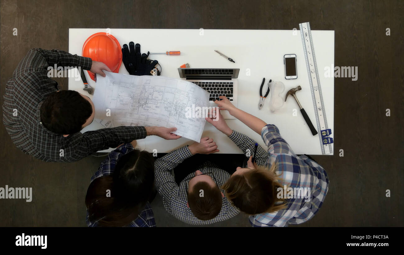 Group of architects discussing technical drawings Stock Photo - Alamy
