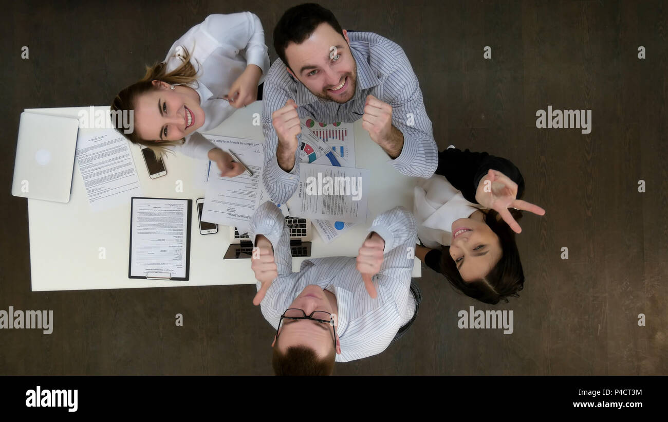 Happy office workers smiling to the camera and showing thumbs up Stock ...