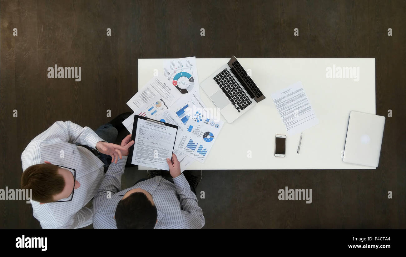 Two managers discussing contract in the office Stock Photo - Alamy