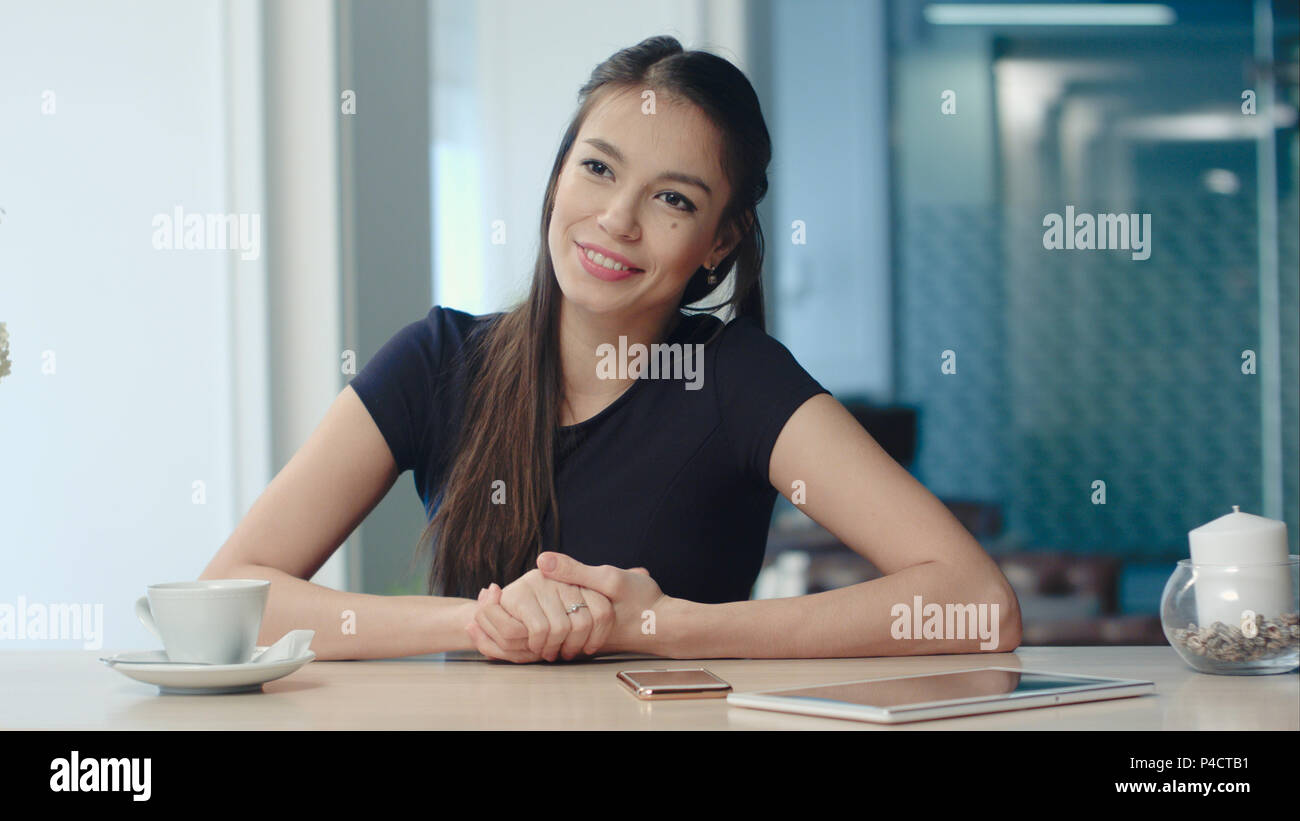 Smiling young woman telling story to a friend in a coffee house Stock ...