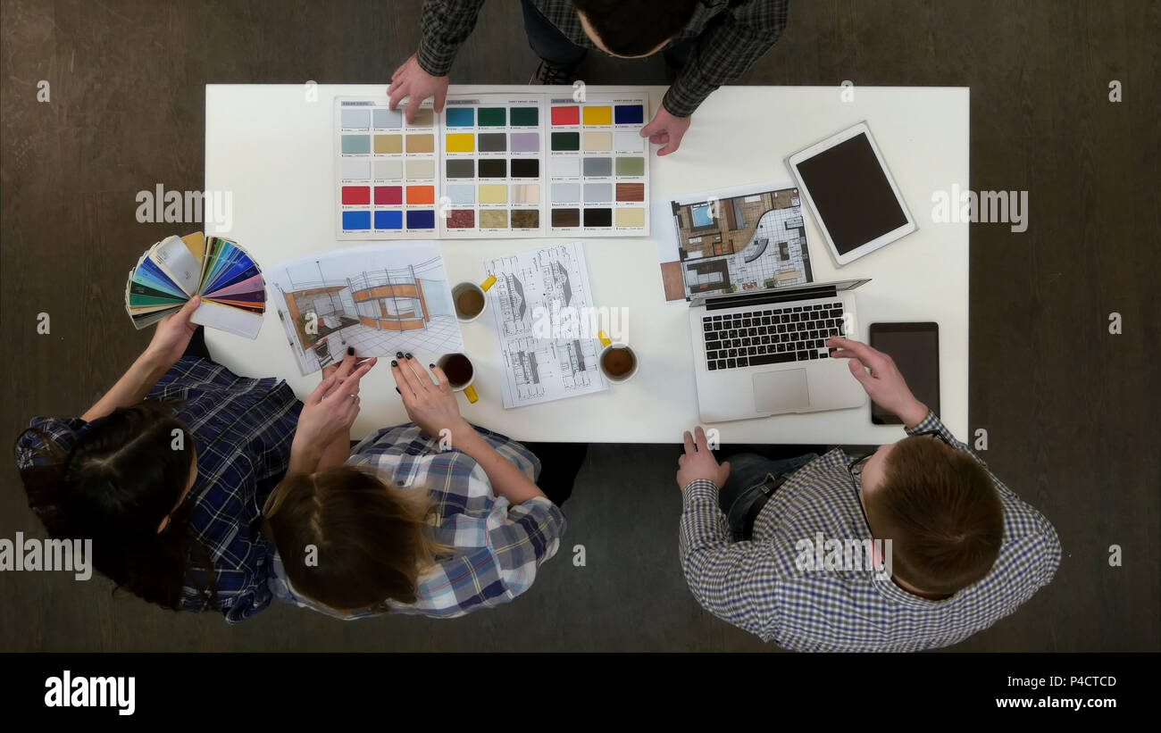 Young designers working with color palette and samples at office desk ...