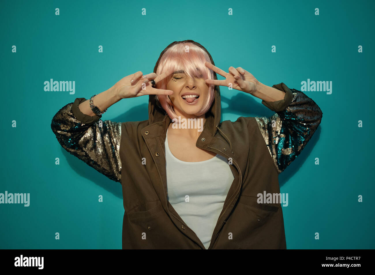 Stylish girl making funny face on blue background Stock Photo - Alamy