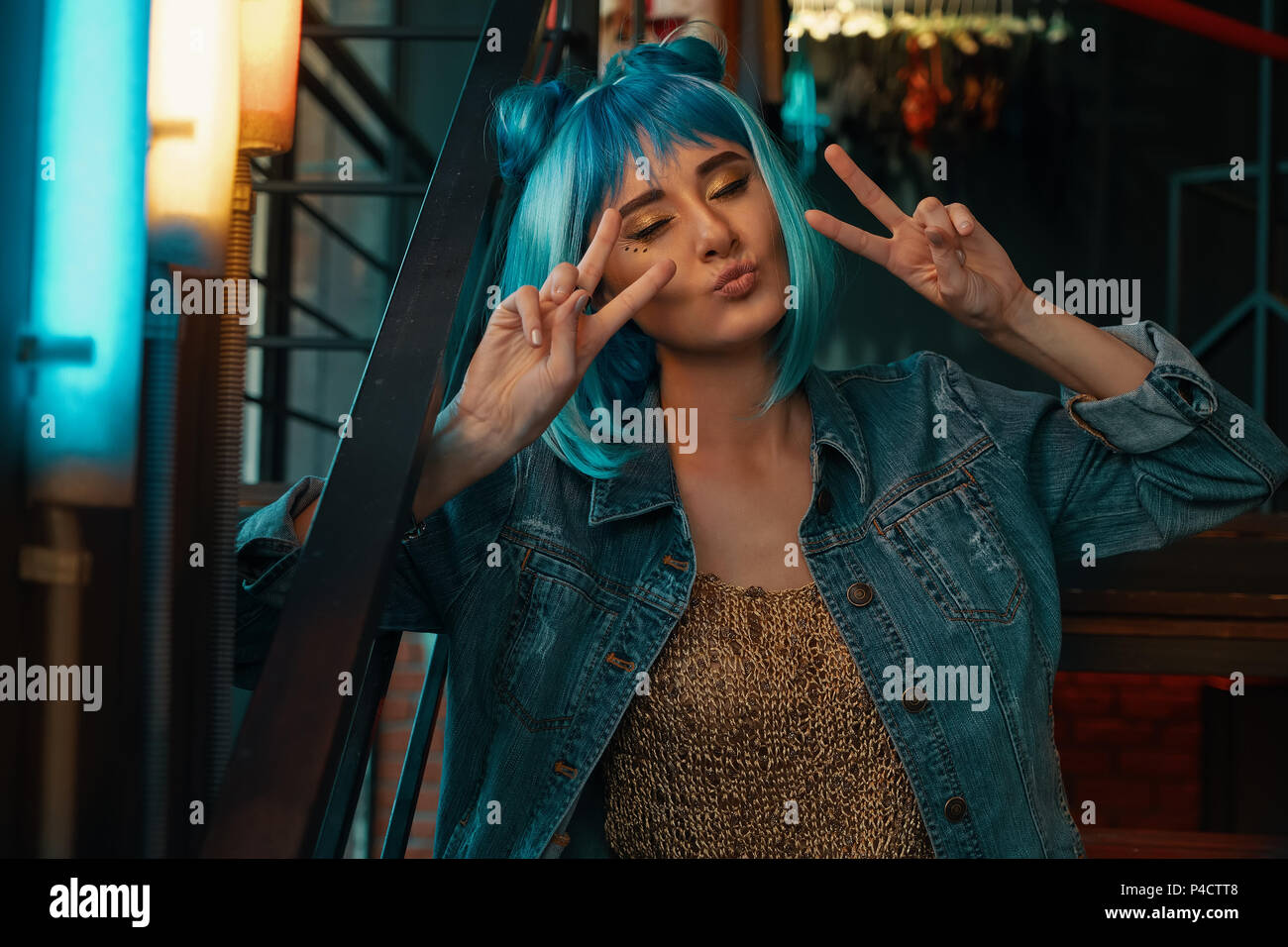 Cheerful girl making duck face while showing victory sign Stock Photo ...