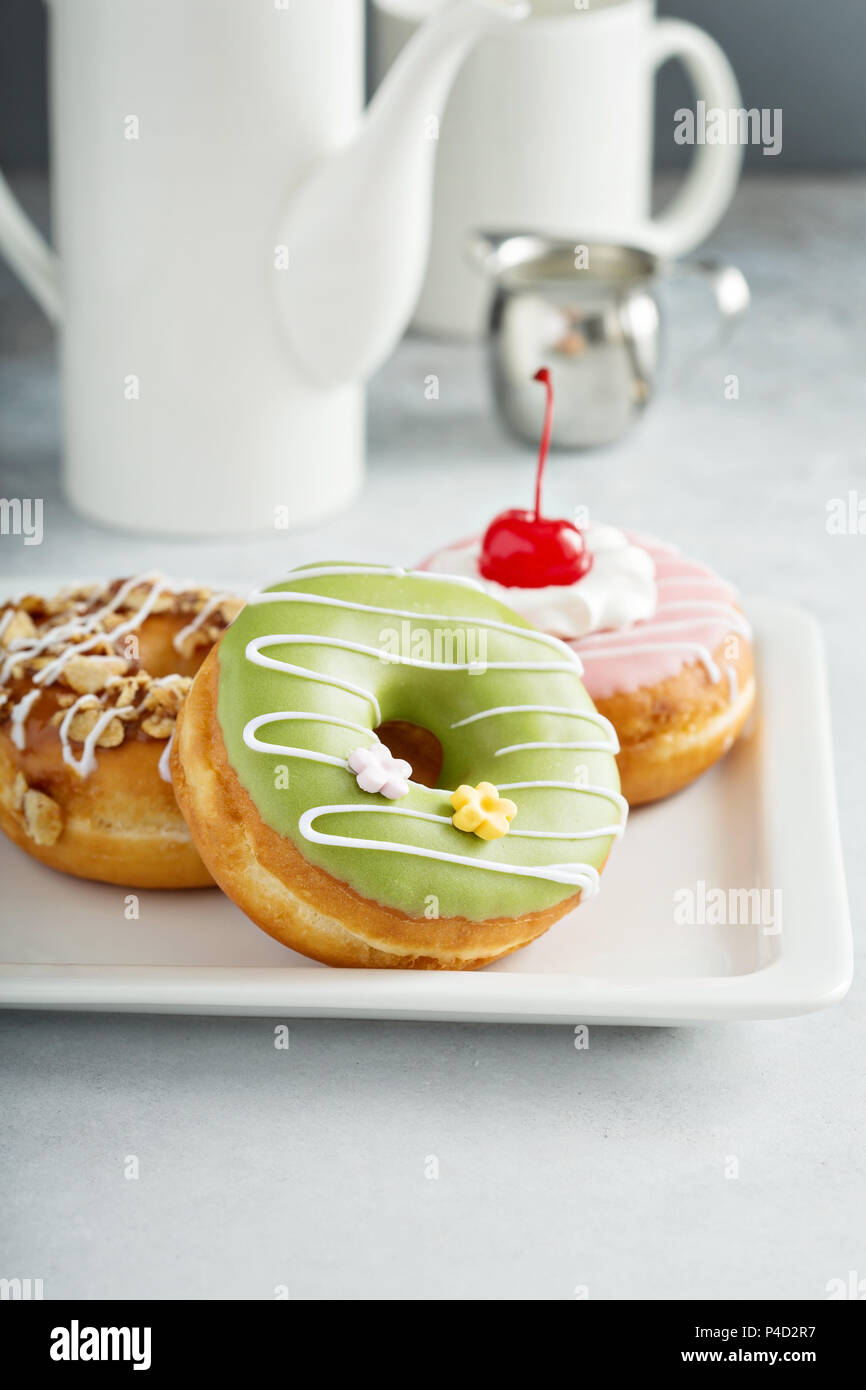 Assorted glazed fried donuts on a plate Stock Photo - Alamy