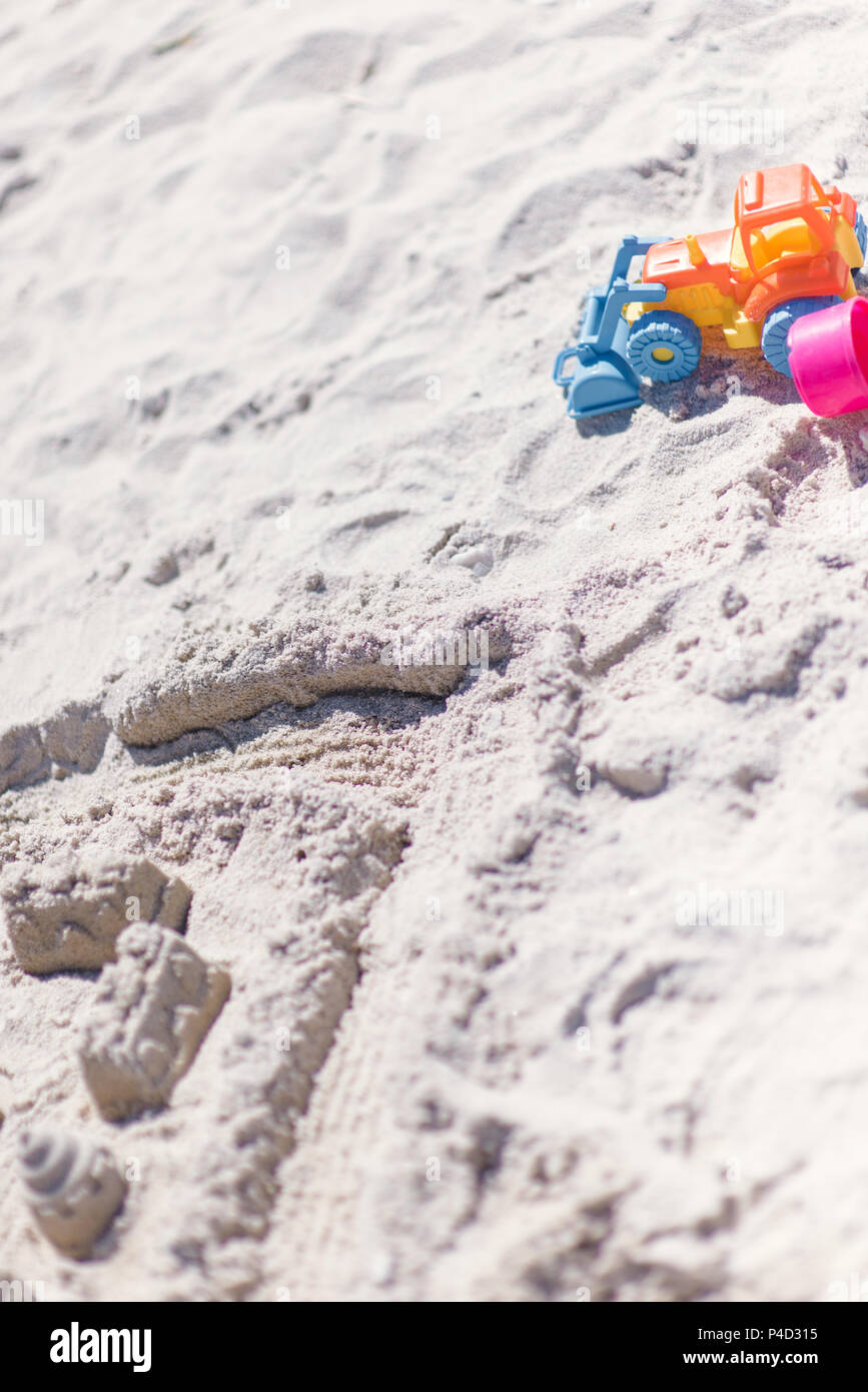 Small but beautiful sand castle on the beach with some toys around and ...
