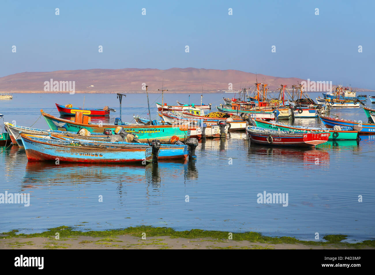 Colorful fishing boats anchored in Paracas Bay, Peru. Paracas is a ...