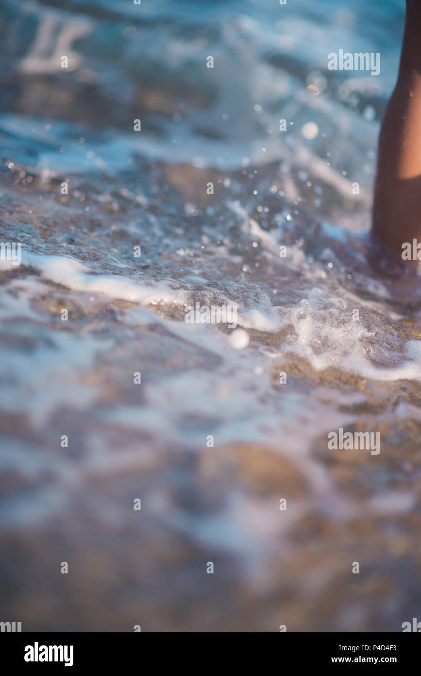 Close up of foamy salt water waves splashing on the golden shores of ...