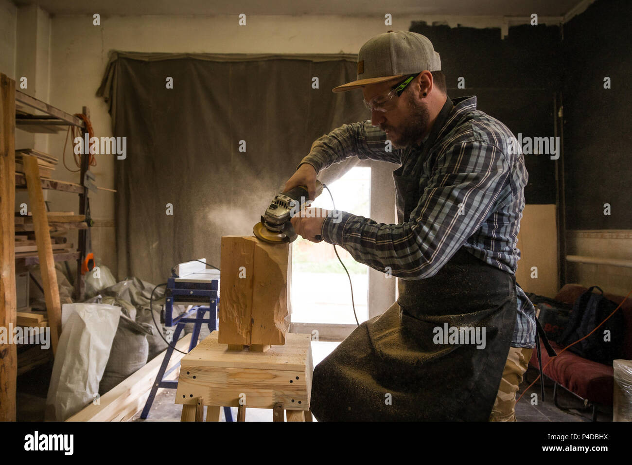 Сarpenter in work clothes and small buiness owner working in woodwork ...