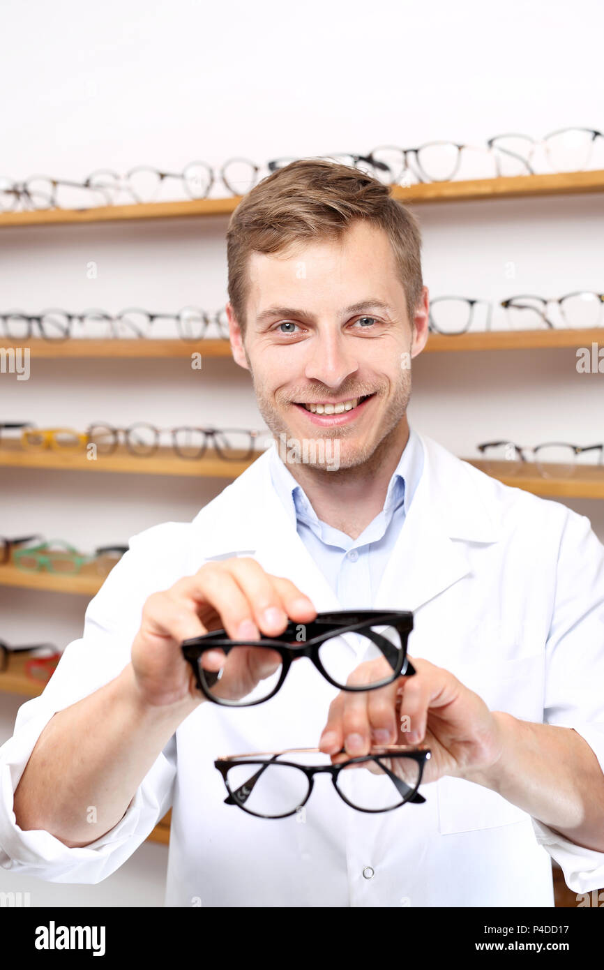 Optician. The man chooses spectacle frames in the optical salon Stock ...