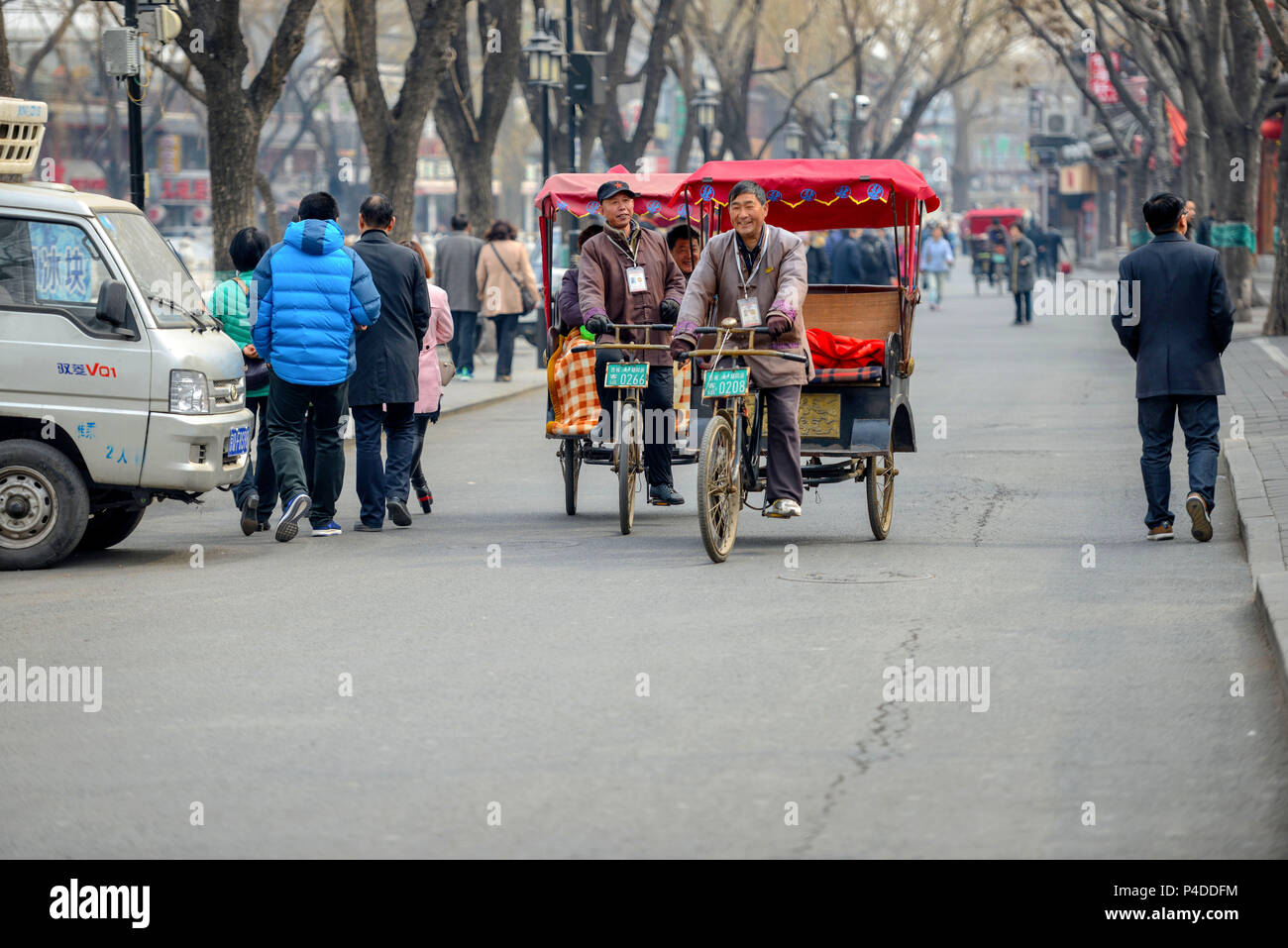 BEIJING, CHINA - MARCH 12, 2016: Tourists in a rickshaw in a hutong ...
