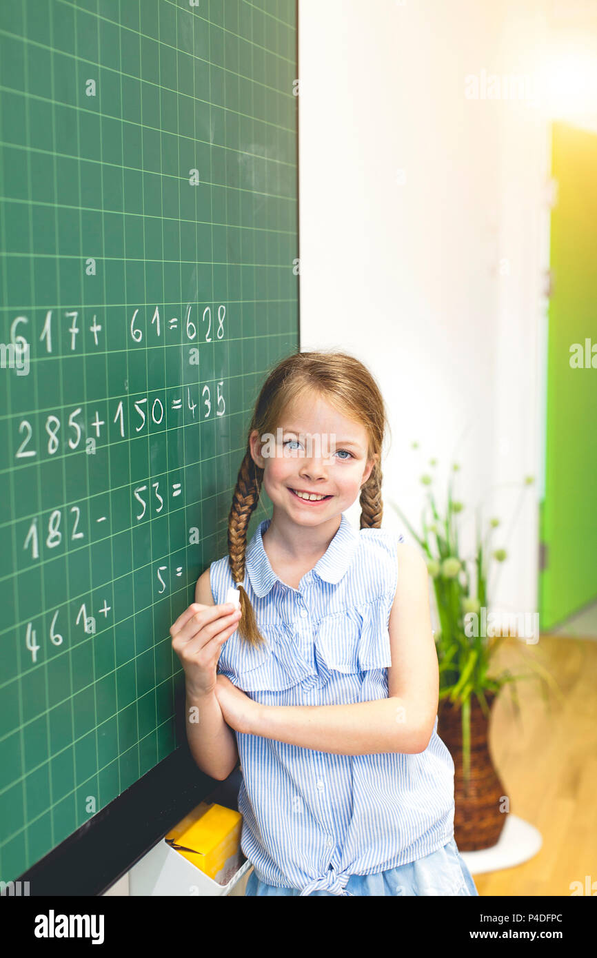 beautiful girl is counting on the blackboard in the classroom Stock ...