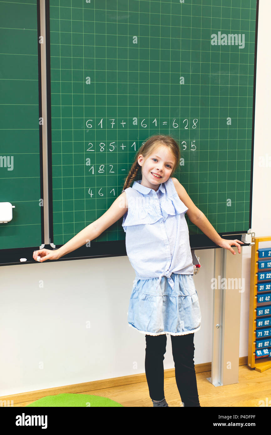 beautiful girl is counting on the blackboard in the classroom Stock ...