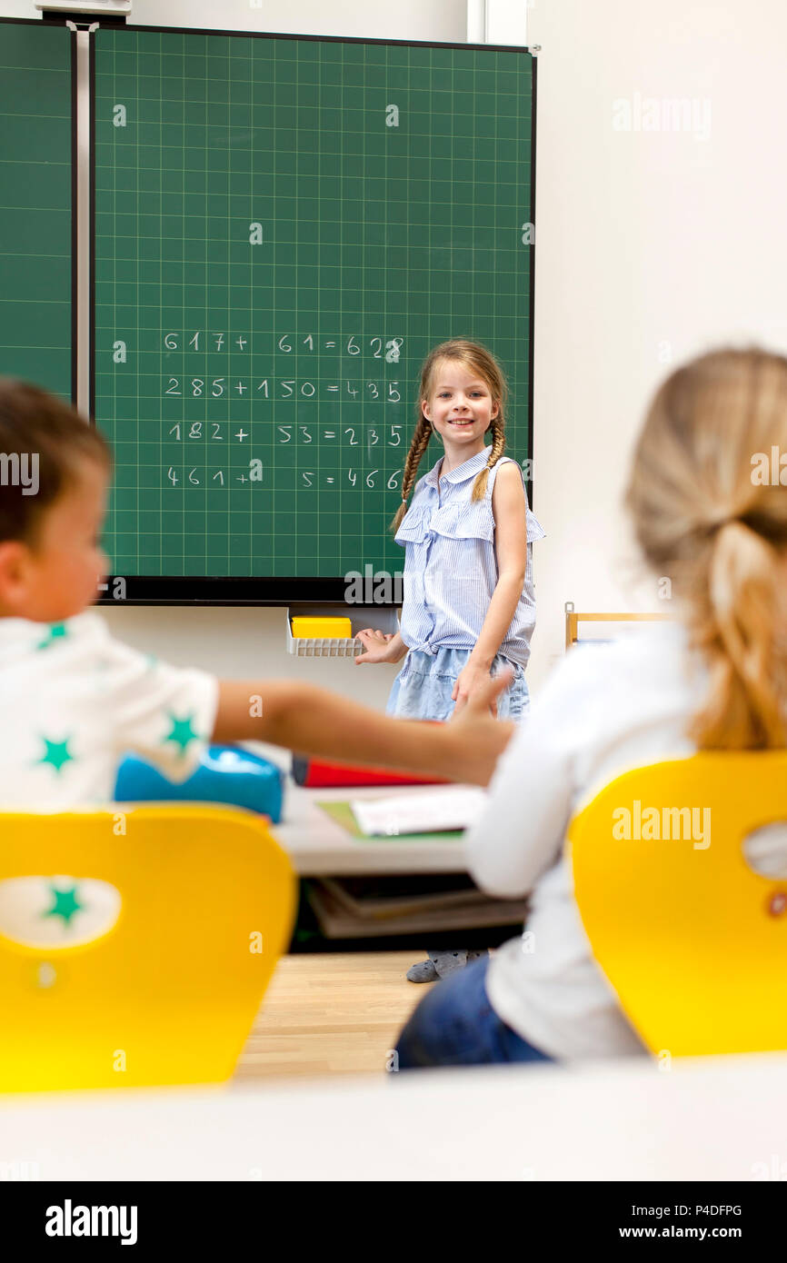 beautiful girl is counting on the blackboard in the classroom Stock ...