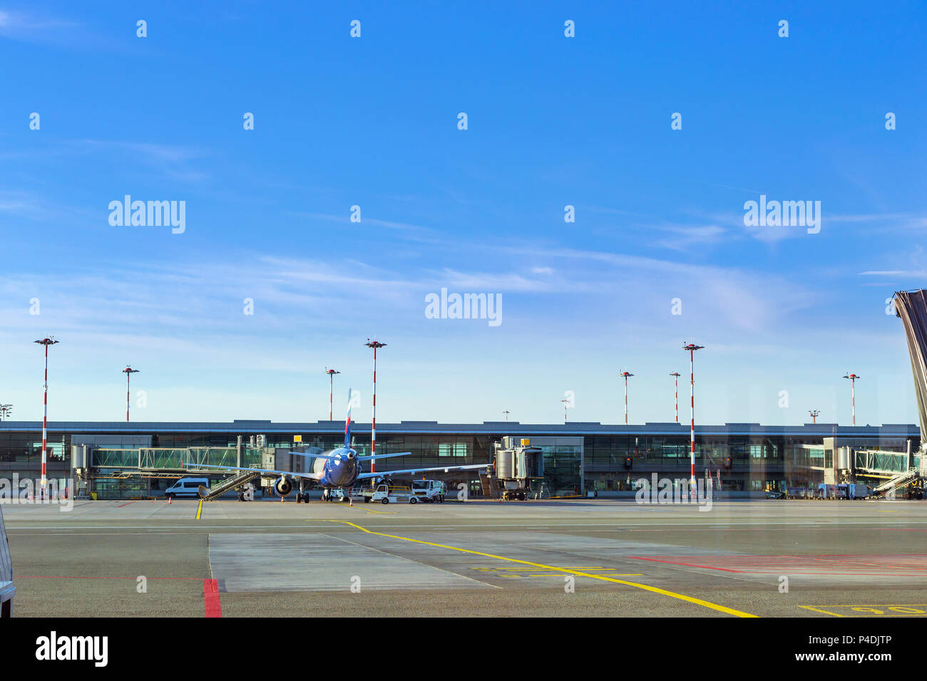 Passenger airplane at stationary terminal gates on airport runway ...