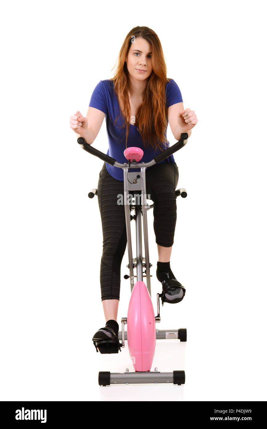 woman doing cardio workout and resting her arms on an exercise bike ...