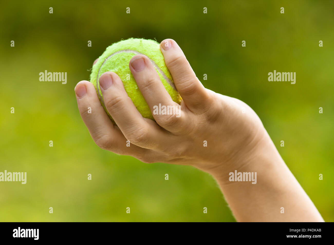 woman hand holding tennis ball on green blurred background Stock Photo ...