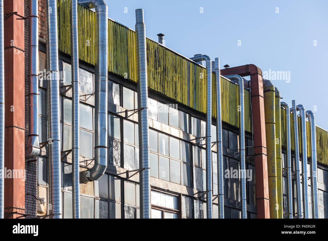 facade of the industrial building with various ventilation tubes on ...