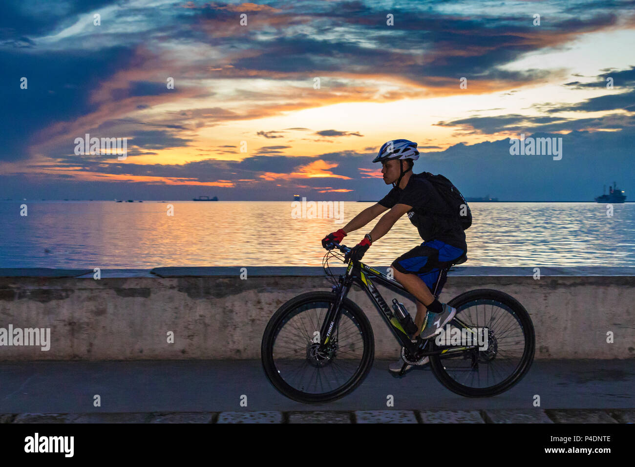 Cyclist at sunset, Manila Bay, Philippines Stock Photo - Alamy