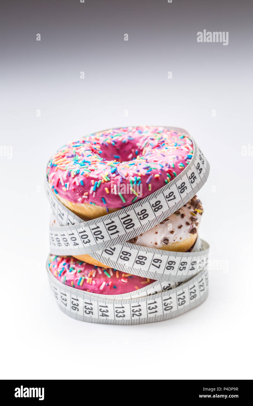 Three colorful donuts wrapped in a tailors measuring tape Stock Photo ...