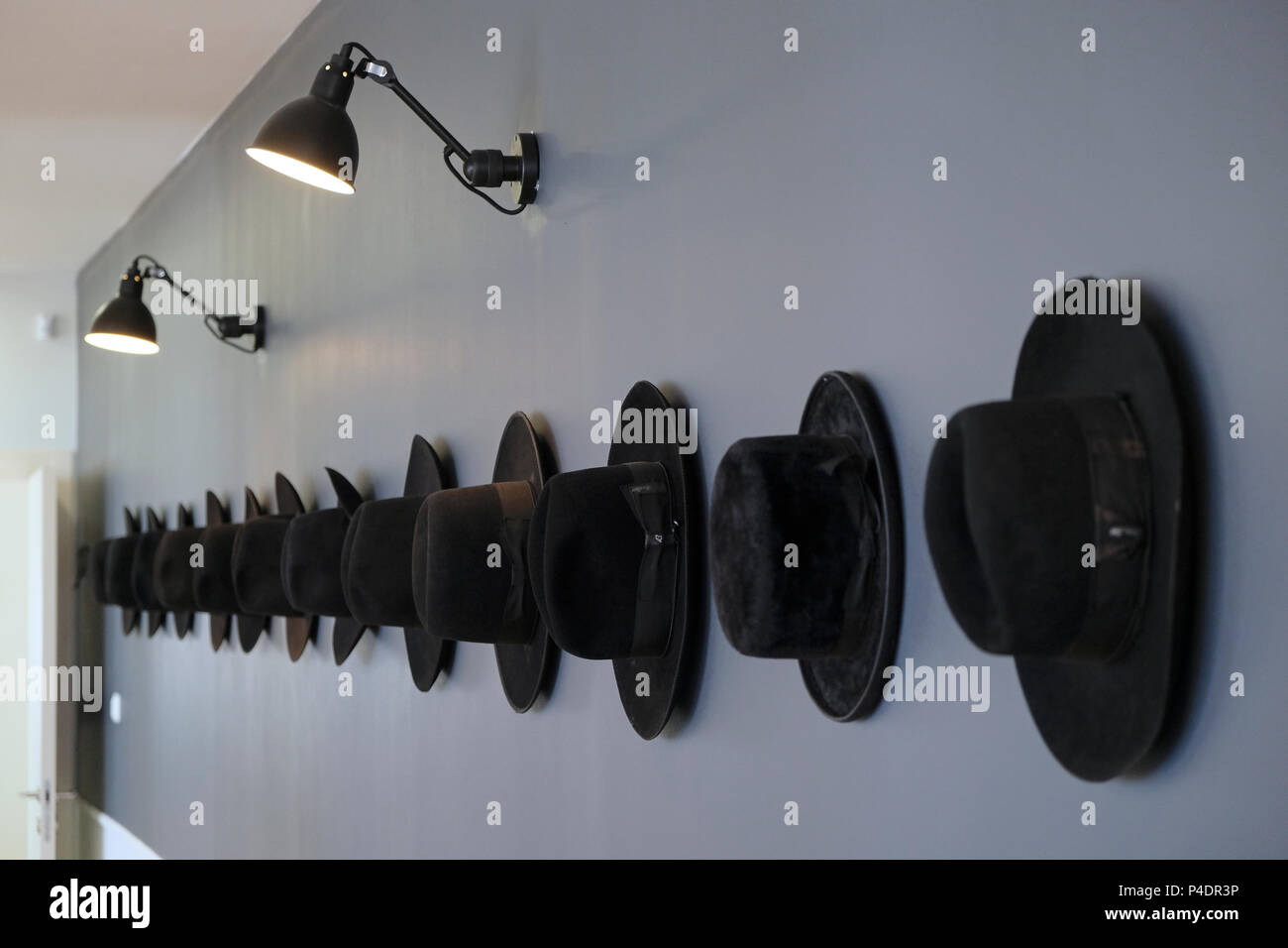 Traditional black Haredi hats hanging on a wall in a corridor of an ...