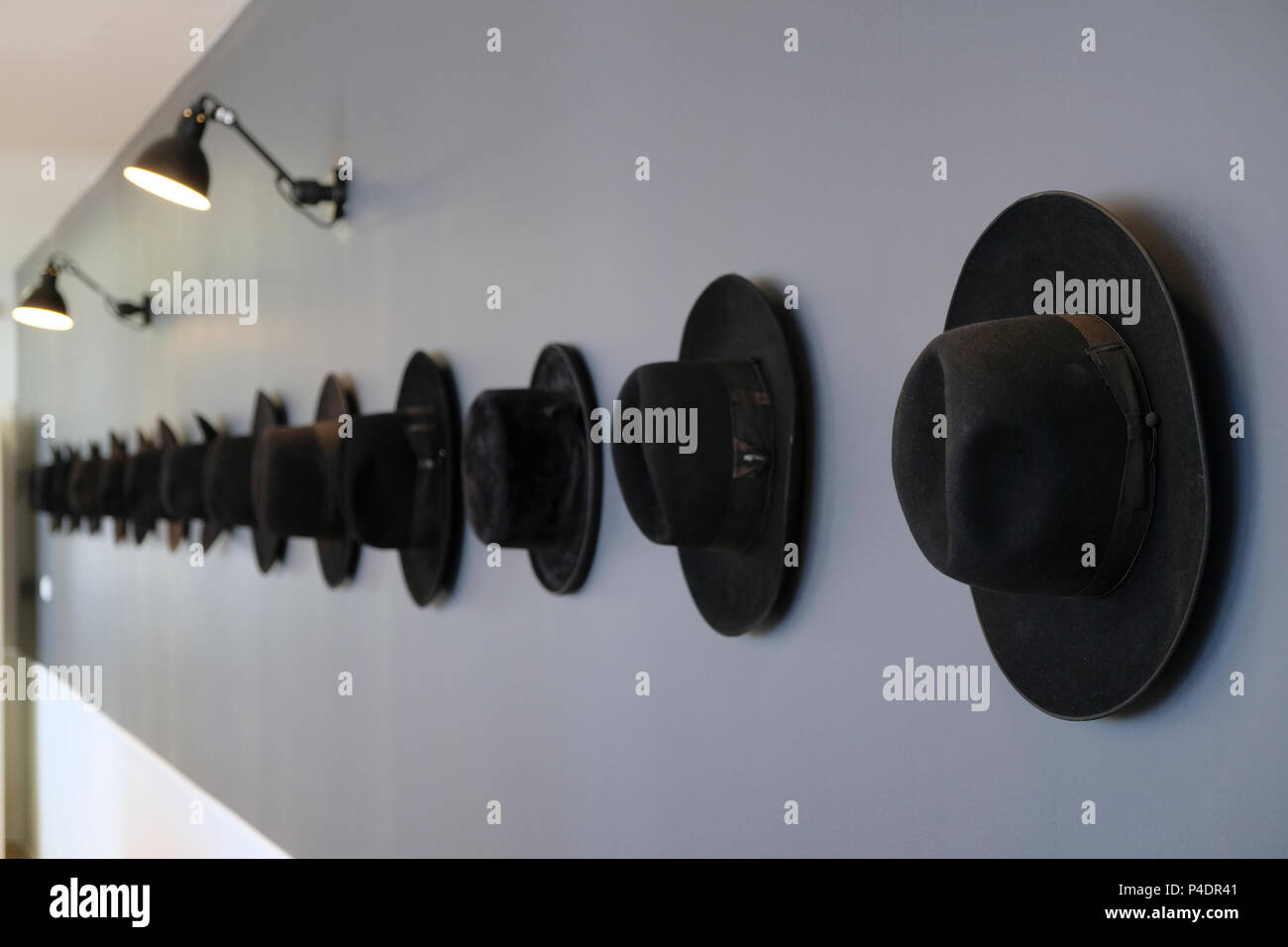Traditional black Haredi hats hanging on a wall in a corridor of an ...