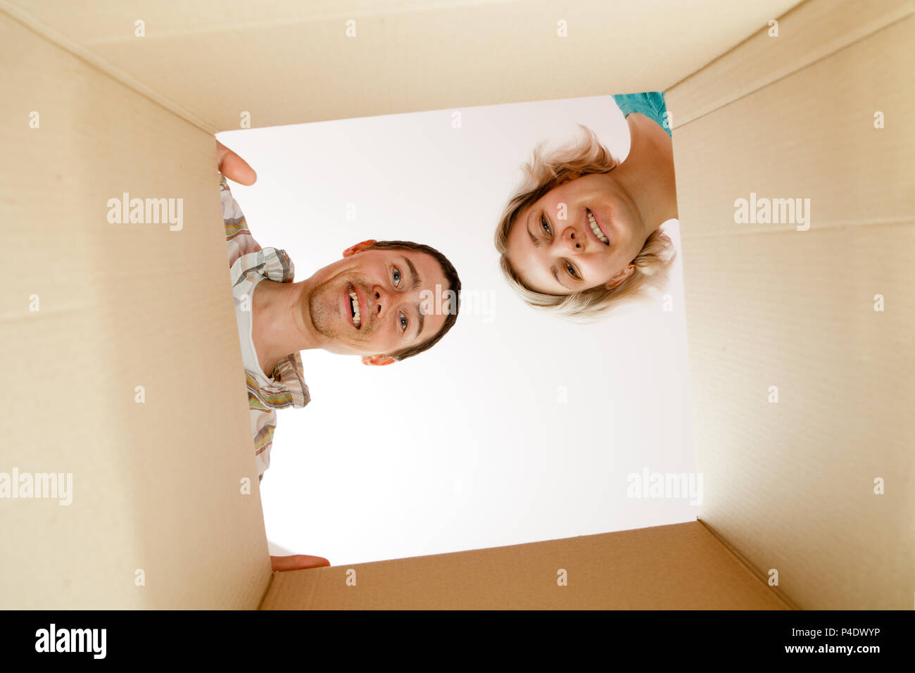 Photo of man and woman peering into cardboard box Stock Photo - Alamy