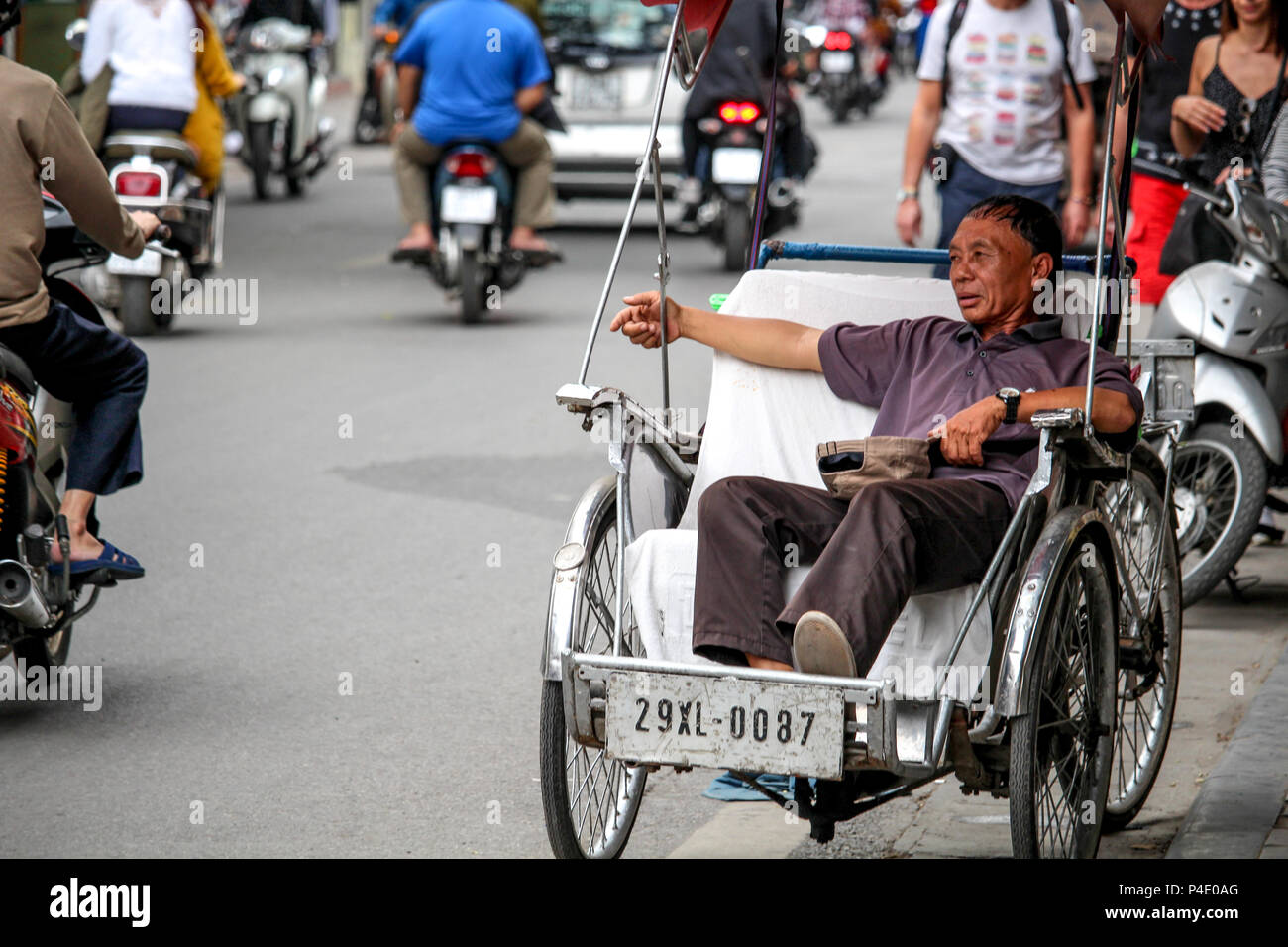 Hanoi, Vietnam - March 15, 2018: Rickshaw driver resting and waiting ...