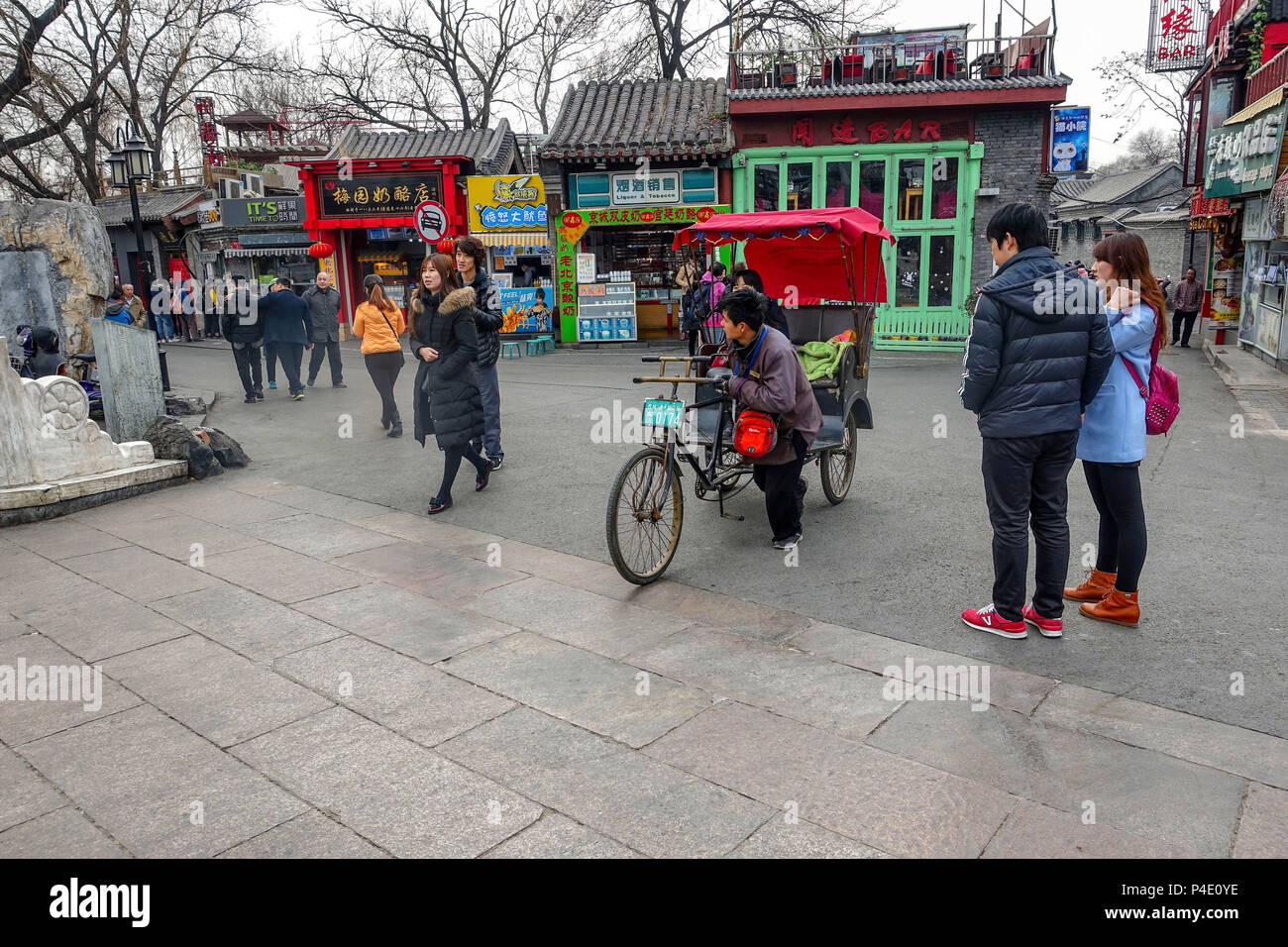 BEIJING, CHINA - MARCH 12, 2016: Tourists in a rickshaw in a hutong ...
