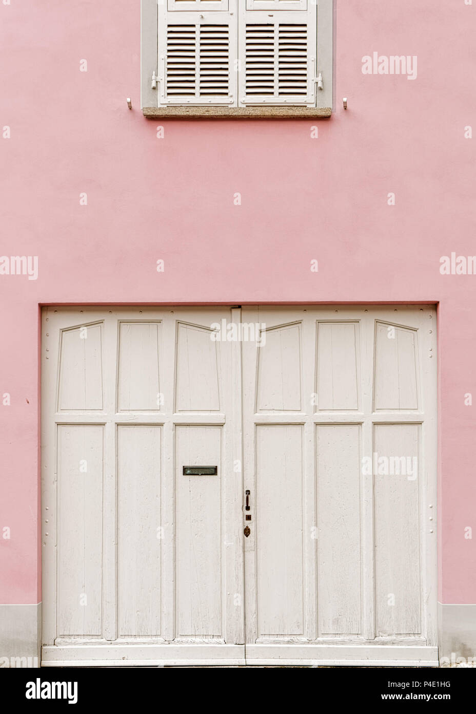 White front gate and window on pink colored house wall, Italy Stock ...