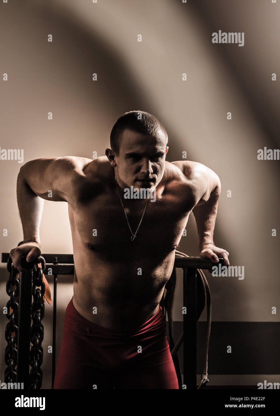 Professional bodybuilder in the gym performs exercises for bodybuilding ...