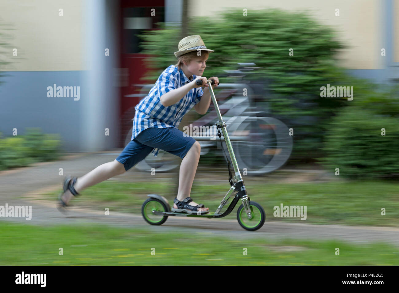 young boy riding his scooter Stock Photo - Alamy