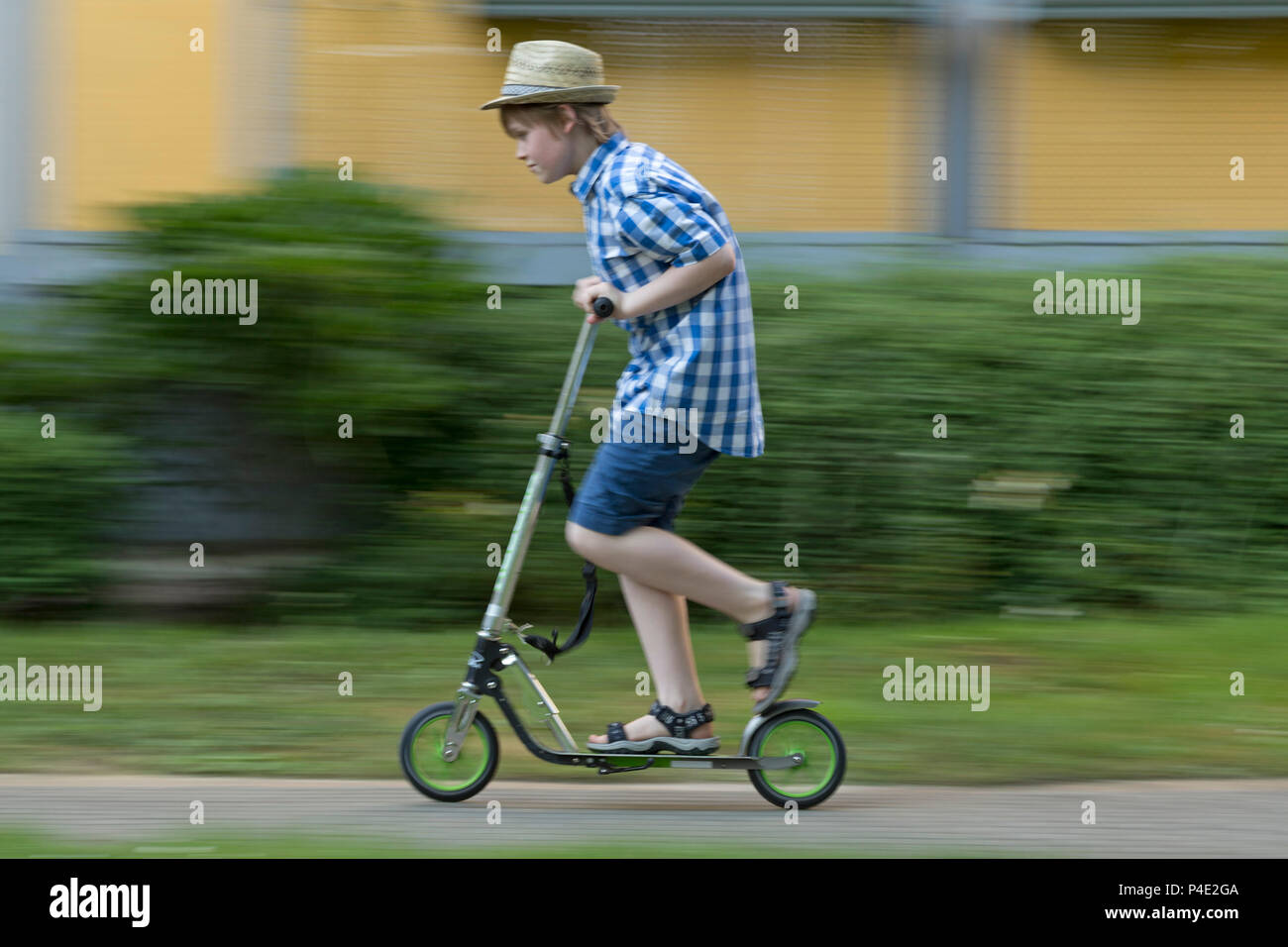 young boy riding his scooter Stock Photo - Alamy