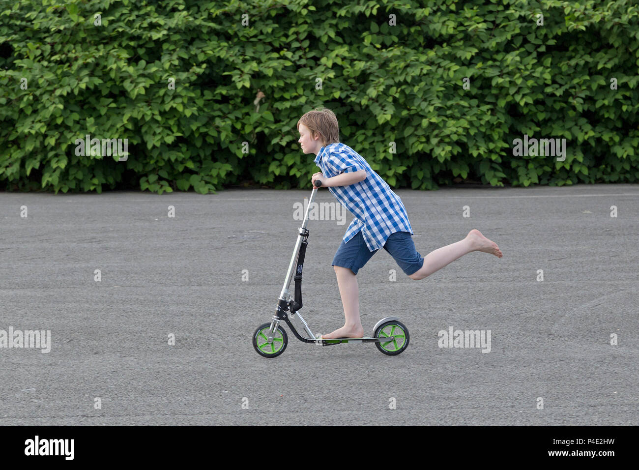 young boy riding his scooter Stock Photo - Alamy