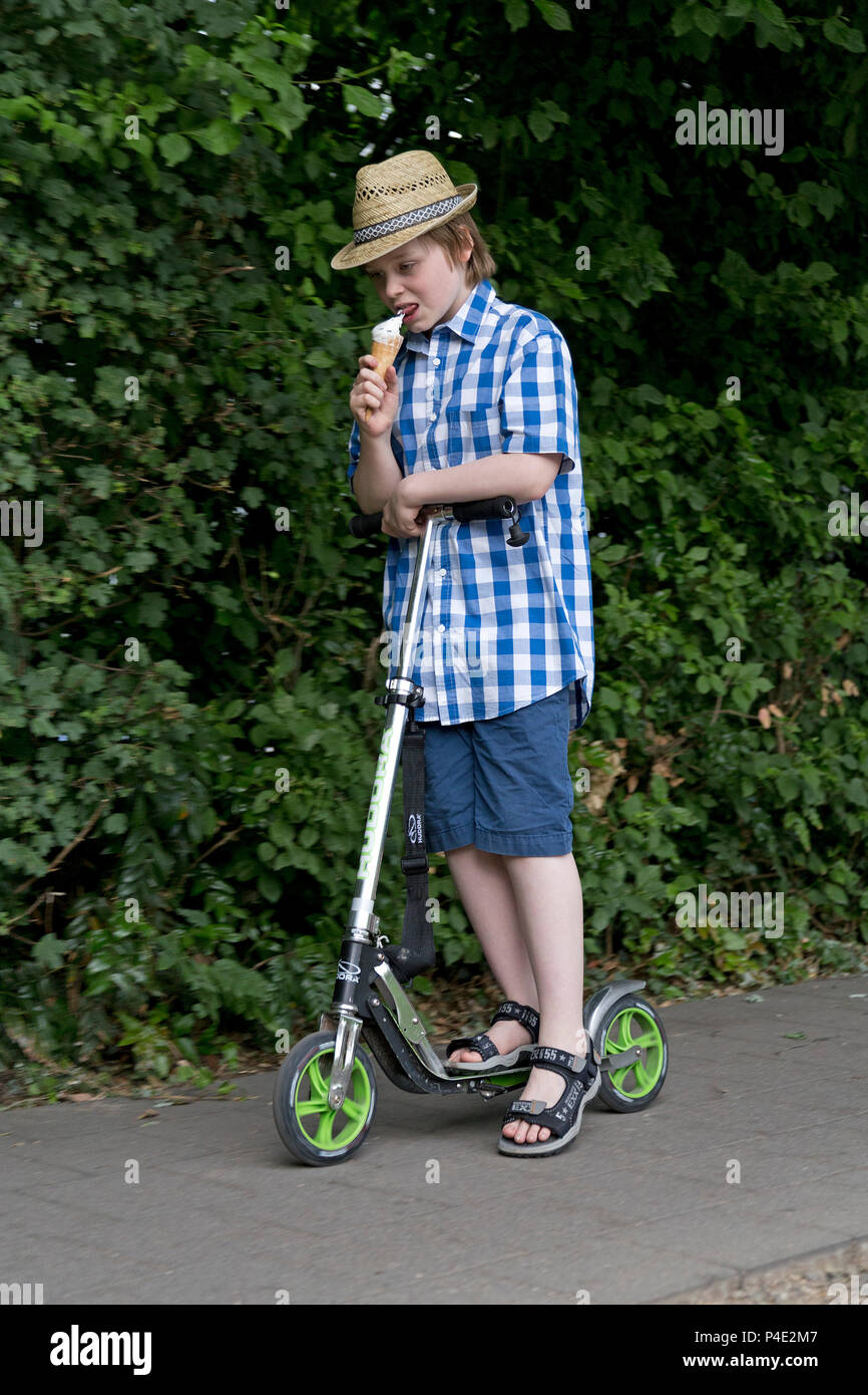 boy with ice cream riding his scooter Stock Photo - Alamy