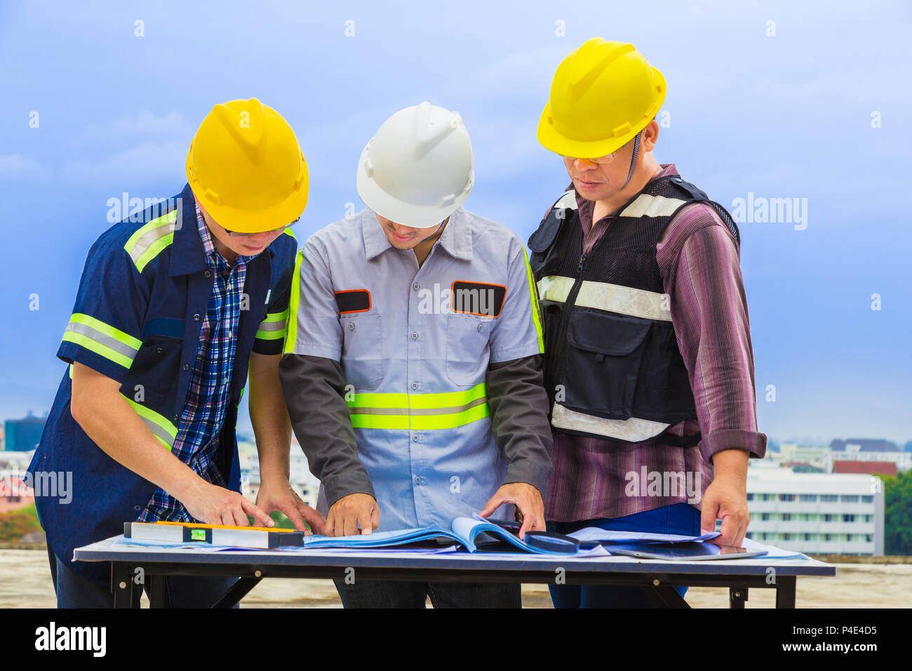 Construction engineers working together looking at the blueprint at ...
