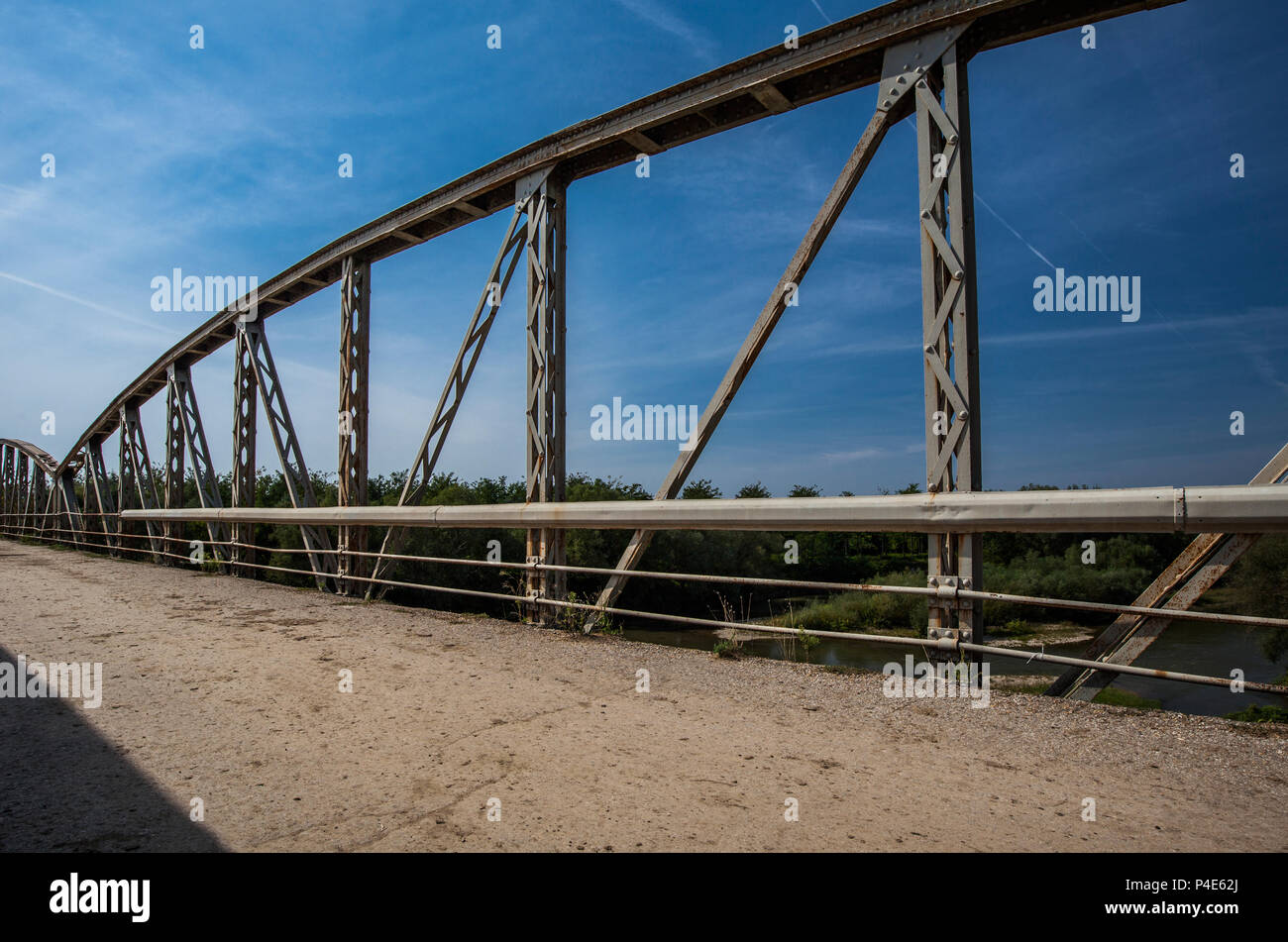 Old rusty railings on the bridge. Road with cracked asphalt Stock Photo ...